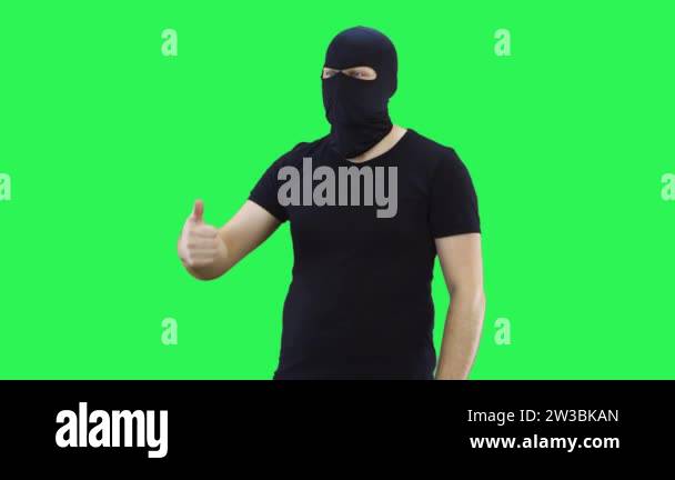 The masked man is showing thumb up.Balaclava.Green screen background ...