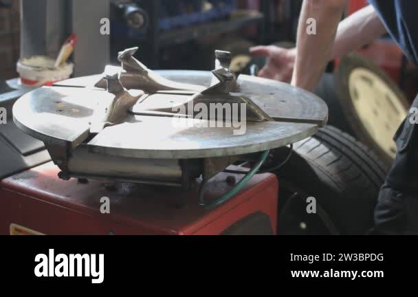 Mechanical repairs a tire in the garage on a tire fitting machine.An ...