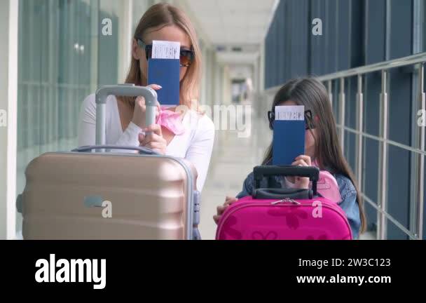 Female and little girl holding passports and airline boarding pass ...