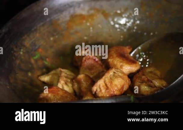 Tossing chicken momos in red spicy gravy with chilly in an Indian style ...