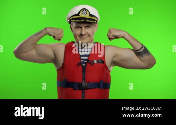 Young muscular sailor man works as lifeguard at beach shows muscles ...