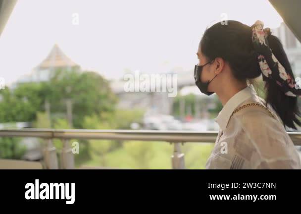 young Asian female wear black protective mask standing and looking at ...