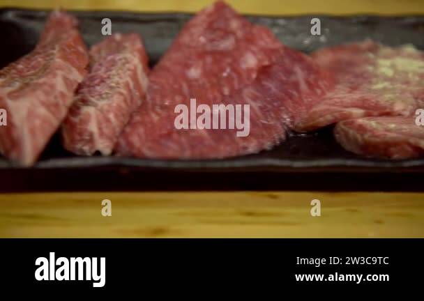 4K, Thinly sliced Japanese wagyu beef on grille for barbecue. Grill one ...