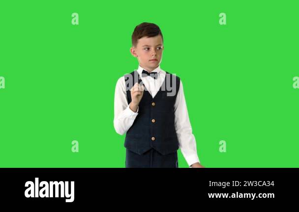 Schoolboy in a bow tie touching virtual screen on a Green Screen ...