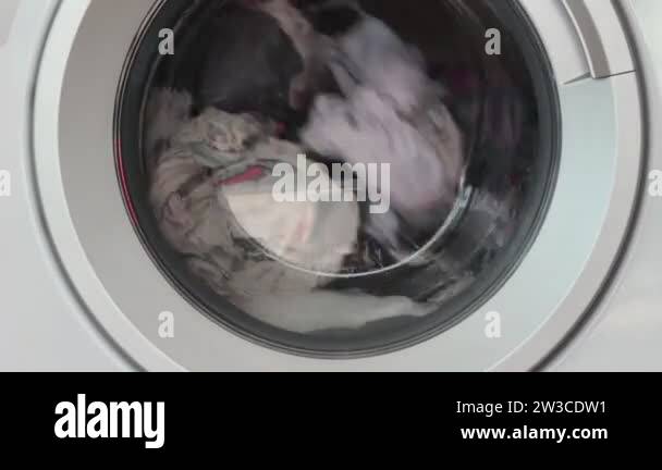washing machine working with rotating garments inside, process of ...