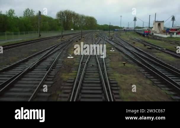 Railroad train passes through railway fork. View on rails from rear ...