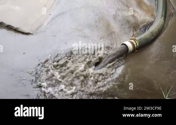 Close-up big pipe of power pump machine pouring mud sludge waste water ...