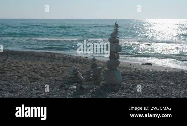 Pyramid of stones on the beach. Heap of pebbles on rocky beach on sea ...
