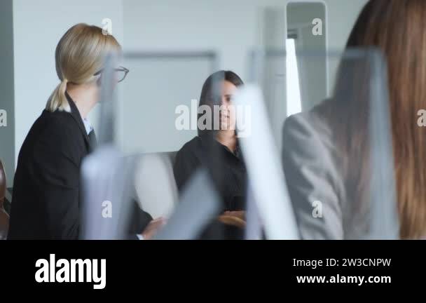 Two Young girls sit on chairs and talk about business. Girls smile and ...