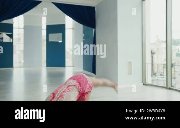 Little girl in performs exercises with clubs for rhythmic gymnastics ...