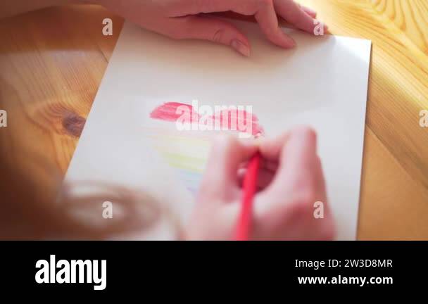 A symbol of love LGBT community. Drawing a rainbow heart on white paper ...