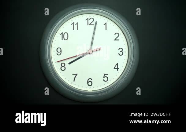 Round clock with white dial There are numbers telling the time in black ...