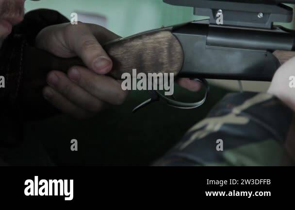 A male shooter hunter takes aim and pulls the trigger of a carbine gun ...