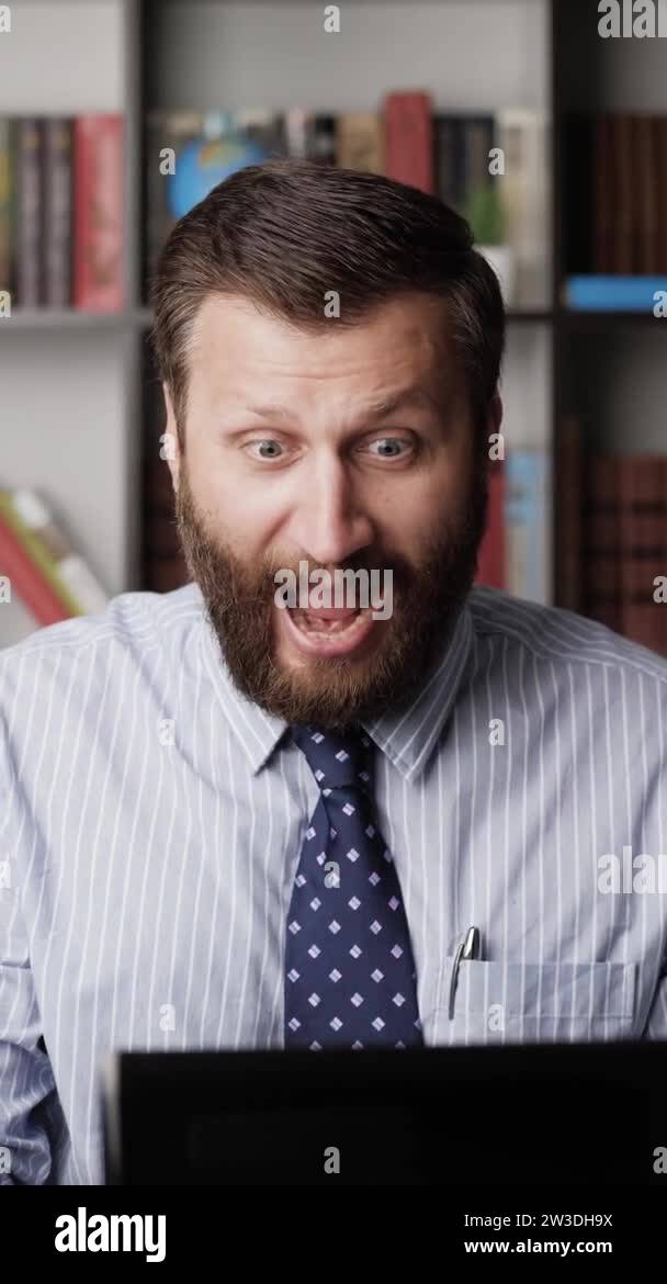 Vertical view worker screaming freaking out. Upset emotional displeased man atworkplace looks at ...