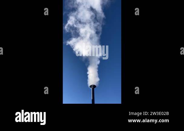 White smoke against the blue sky. Air pollution by smoke coming out of ...