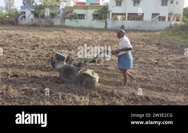 Chennai, India - February 11th 2021: Senior farmer using an old tractor ...