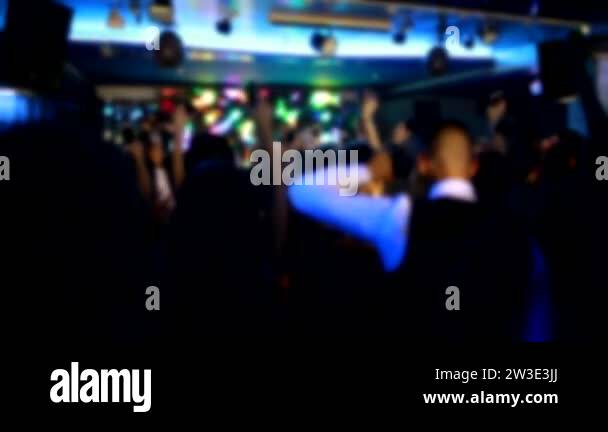 People wave their arms and hold light from flashlights in a nightclub ...