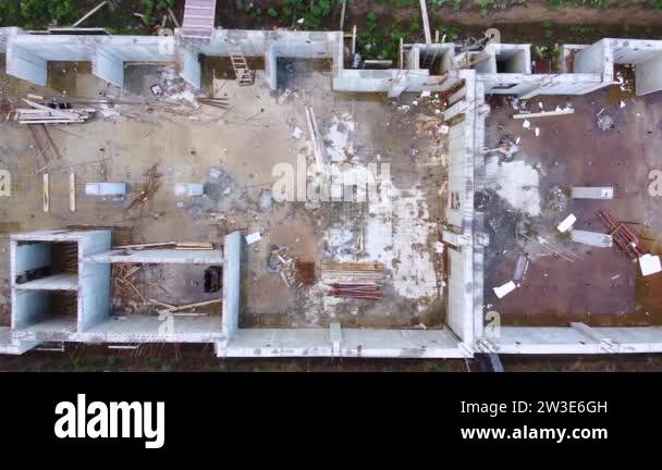 Flat top from the copter onto abandoned construction site with unfinished building frame and ...