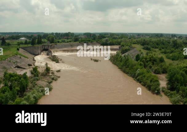 Aerial drone view. River water move down from with a water filled dam ...