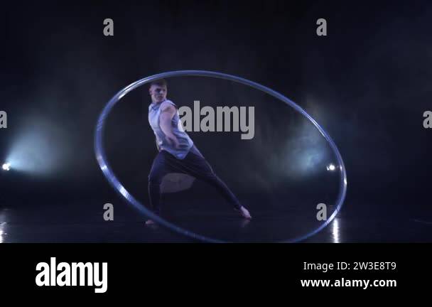 Male muscular acrobat shows difficult tricks for a balance and ...