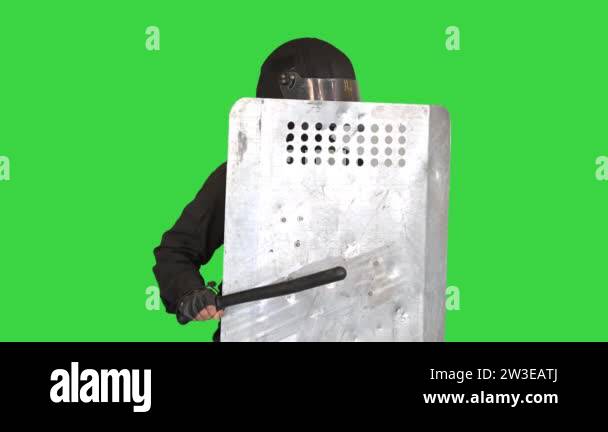 Riot Police unit holding position covering with a shield and holding a ...