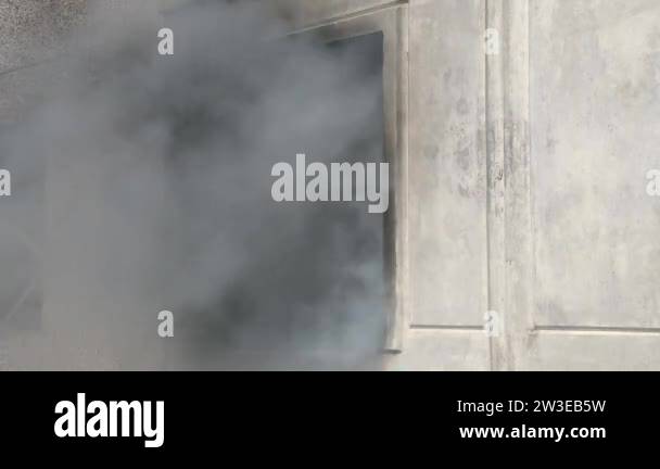 Close up of window of an apartment building from which smoke comes out ...