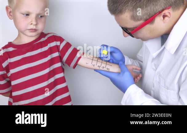 An allergist doctor makes a skin test for allergies. The boy is being ...