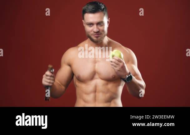 Shirtless bodybuilder eating apple. Portrait of a handsome man with ...