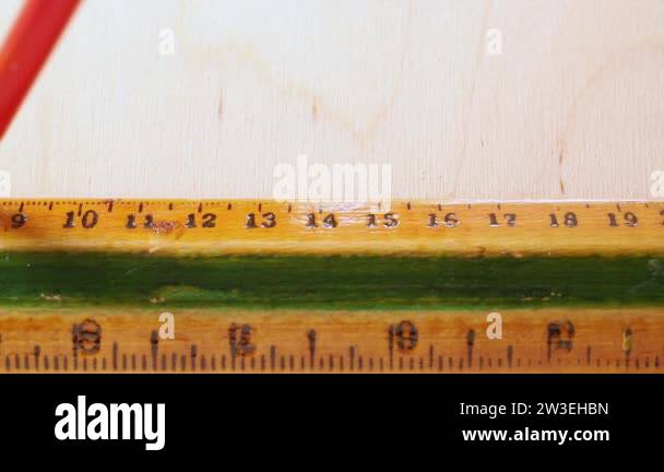 Drawing straight line on wooden background with wooden ruler and pencil ...