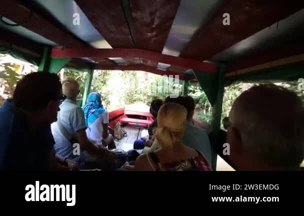 Tourists cruising through a small river part of the Commewijne river in ...
