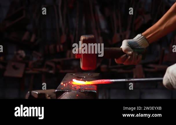 slow motion close up hand with the hammer of blacksmith man forges a ...