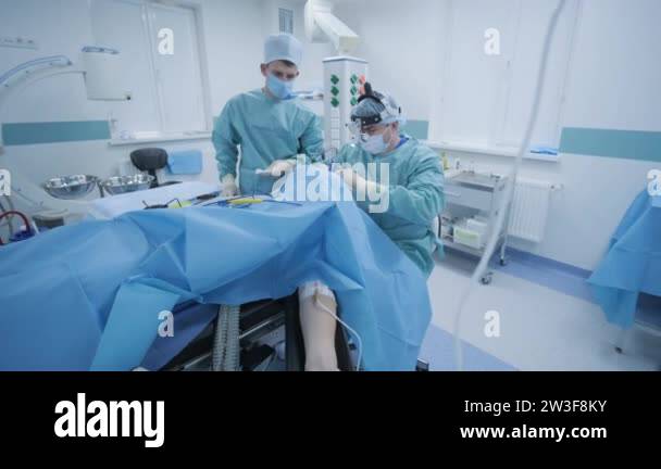 Operation of removing tonsils under deep anesthesia, surgeon uses ...