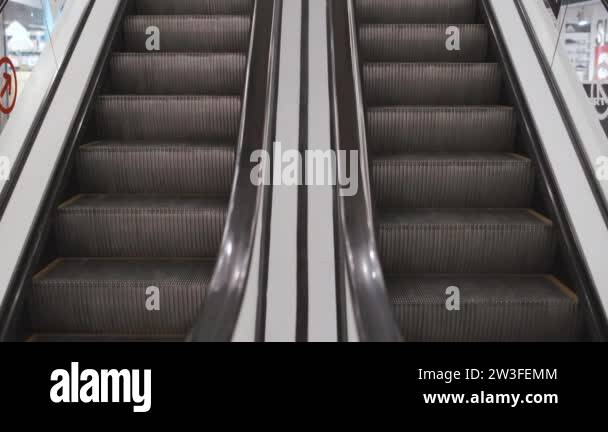 Movement up and down of escalators in metro of shopping mall. Moving staircase without people ...