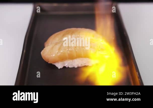 process of preparation of sushi rolls, burning of smoking fire of fish ...