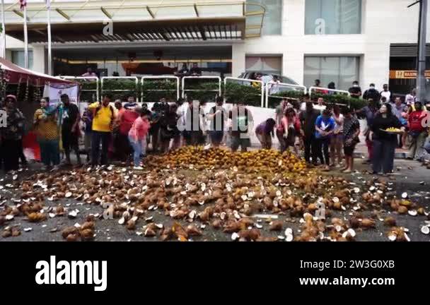 Gimbal shot devotees smash coconut on floor during Thaipusam Stock ...