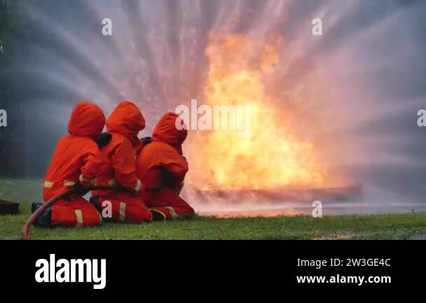 Firefighter fighting with fire flame protection property. Fireman wear ...