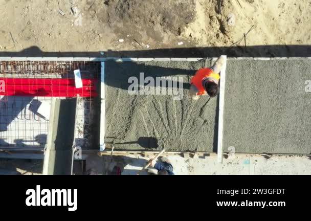 Above top view, overhead on construction worker is using rake and ...