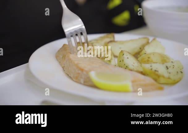 Extreme close-up of red fish and fried potato on hospital ward tray ...