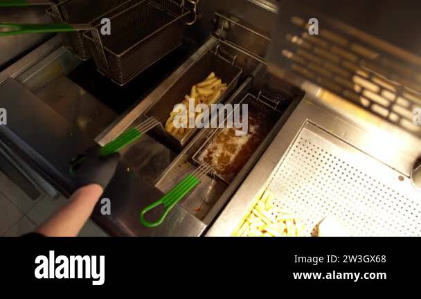 Frying french fries in oil in fast food restaurant kitchen. Overhead ...