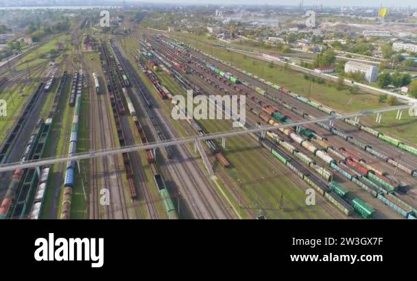 Fly over a large railway junction. Freight trains stand at the railway ...