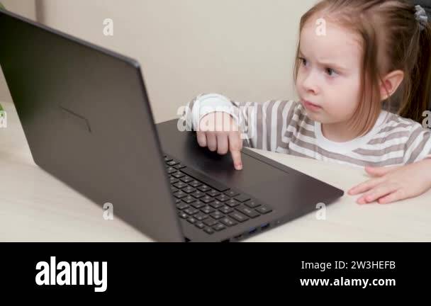 Child learns to use computer. A small child plays at computer at the ...