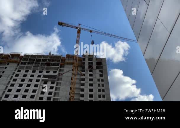 Tower crane on a construction site lifts a load. Building a concrete ...
