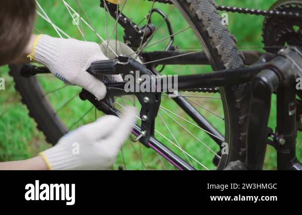 A bicycle repair specialist unscrews the bolts using a hex wrench on ...