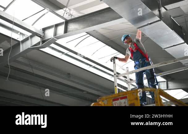 HVAC Installer On Scaffold Assembling Air Ventilation Shaft In Silver ...