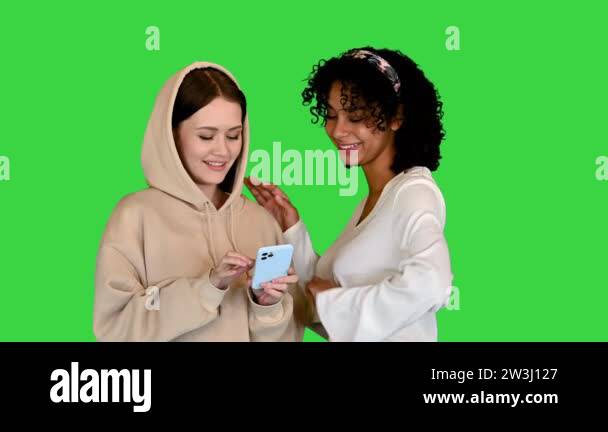 African American and a Caucasian girl surfing the mobile Internet on a ...