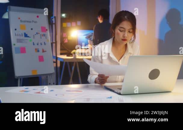 Asian businessman turn off computer and say goodbye his colleague who ...