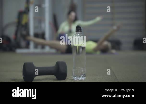Close-up of hand weights and water bottle standing on the floor in gym ...