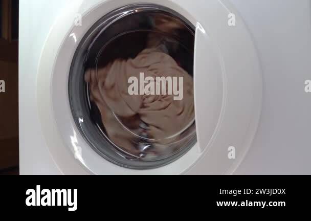 Dirty things rotate in the washing machine, side view. Washing things ...