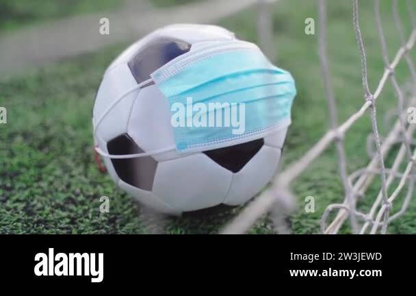 Soccer Ball in Medical Mask on Stadium Green Grass. Ball in Goal Net ...