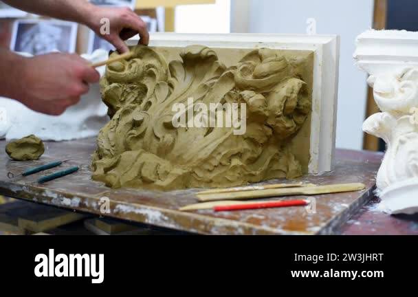 Sculptor create clay model of a Corinthian capitel with scrolls and ...